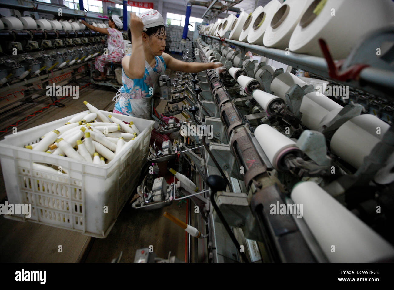Female Chinese workers handle production of yarn to be exported to Southeast Asia at a textile ...