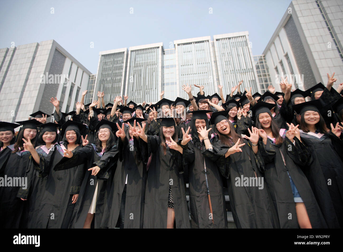Chinese graduates dressed in academic costumes celebrate during a ...