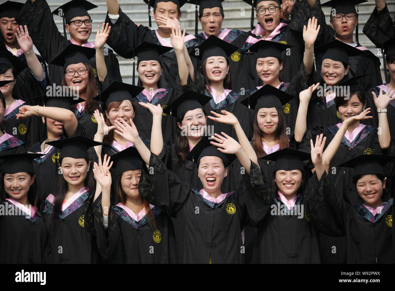 Chinese graduates dressed in academic costumes celebrate during a ...