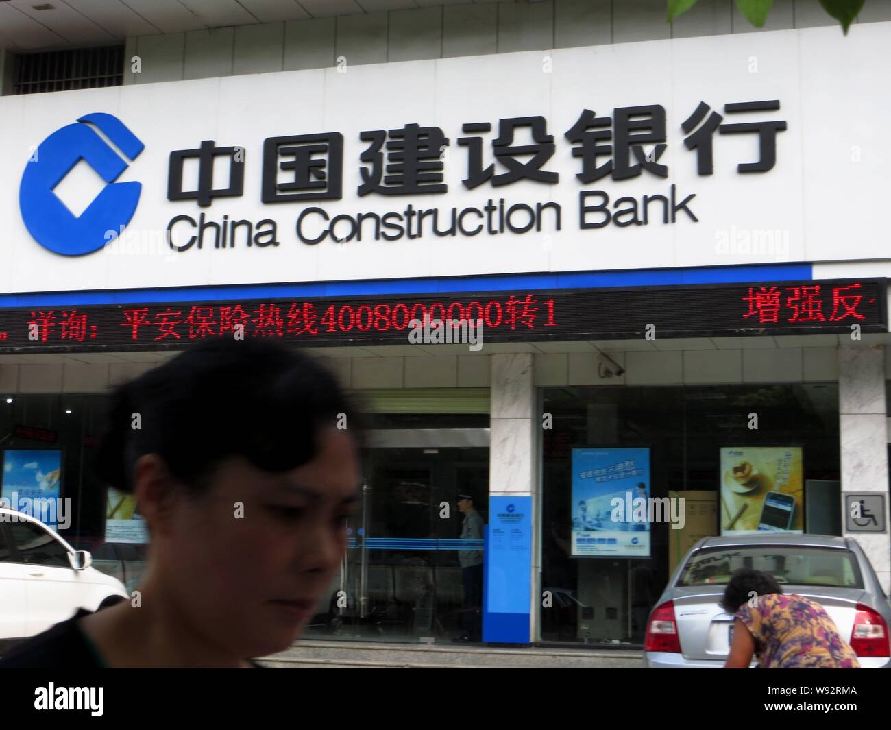 A pedestrian walks past a branch of CCB (China Construction Bank) in ...