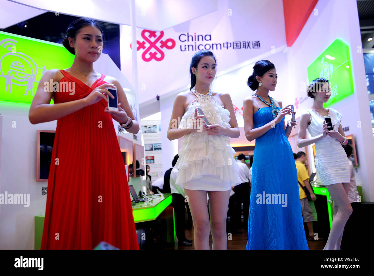 --FILE--Models pose with 4G smartphones at the stand of China Unicom ...
