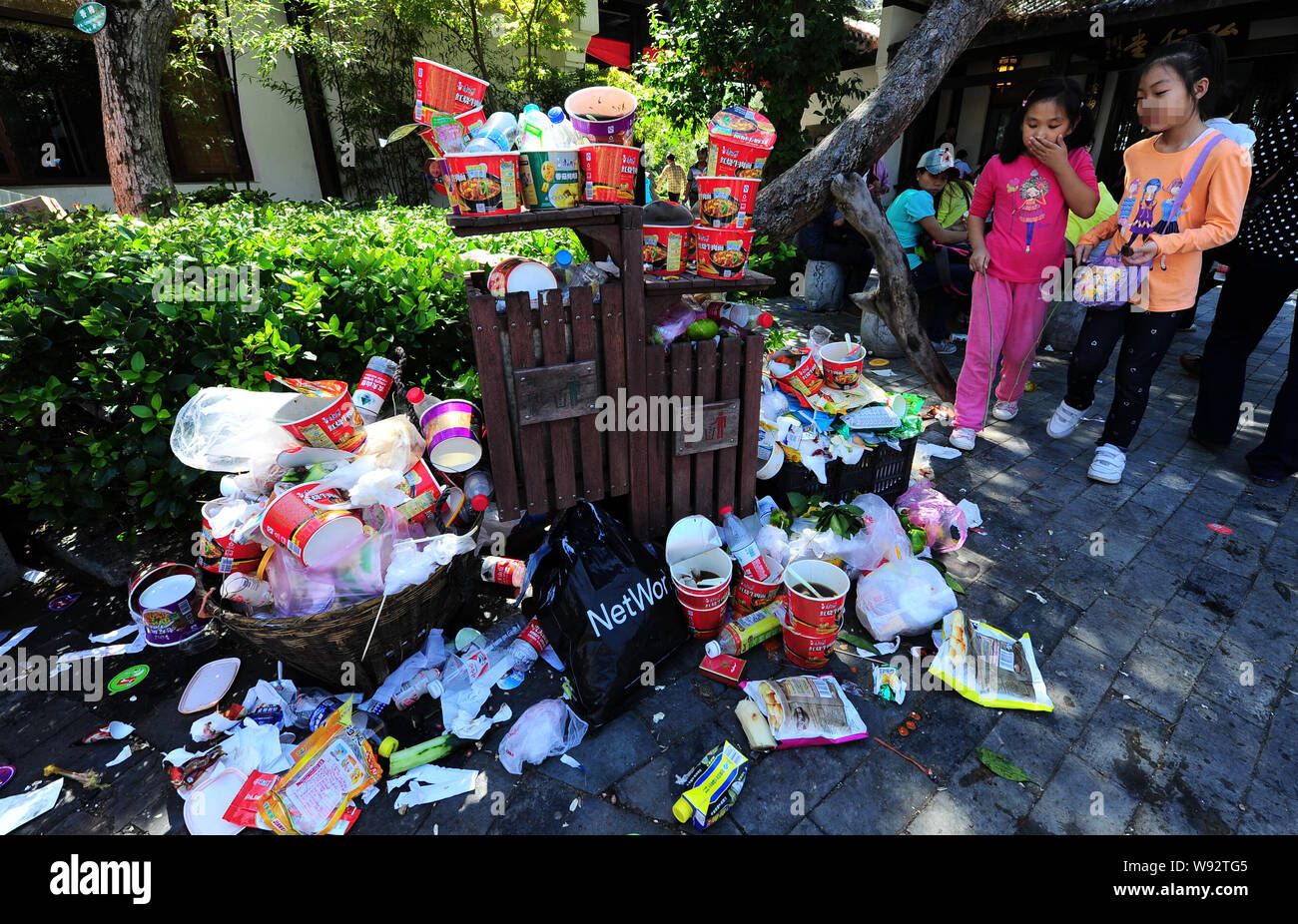 Two Chinese children look at piles of garbage littered by tourists at ...