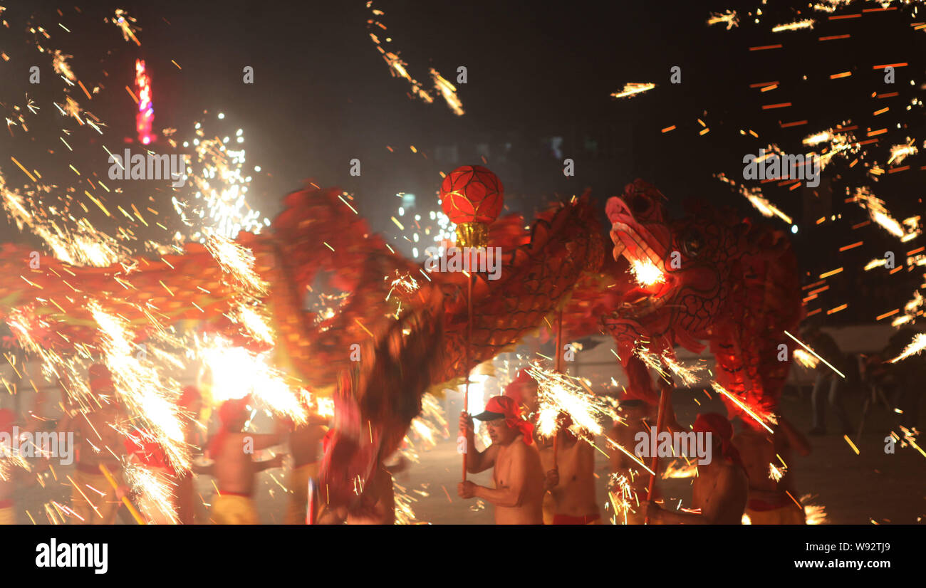 Dancers perform a fire dragon dance in a shower of molten iron during a ...