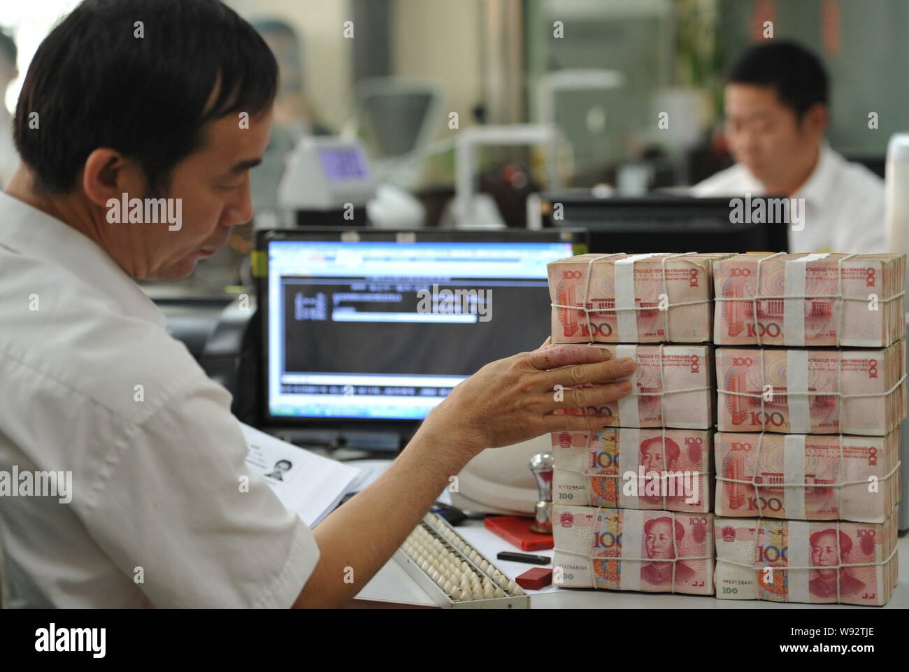 --FILE--Chinese clerks count RMB (renminbi) yuan banknotes at a branch ...