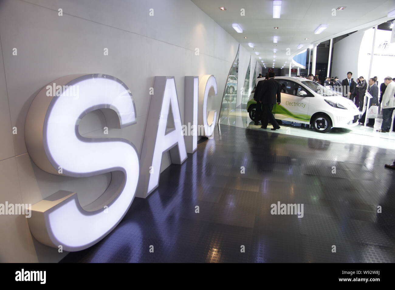Visitors look at a Roewe e50 electric car of SAIC Motor during the 15th ...
