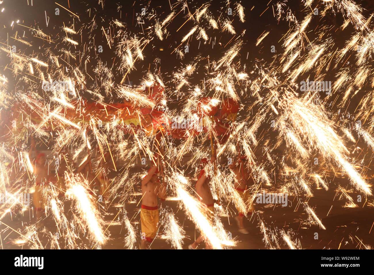 Dancers perform a fire dragon dance in a shower of molten iron during a ...