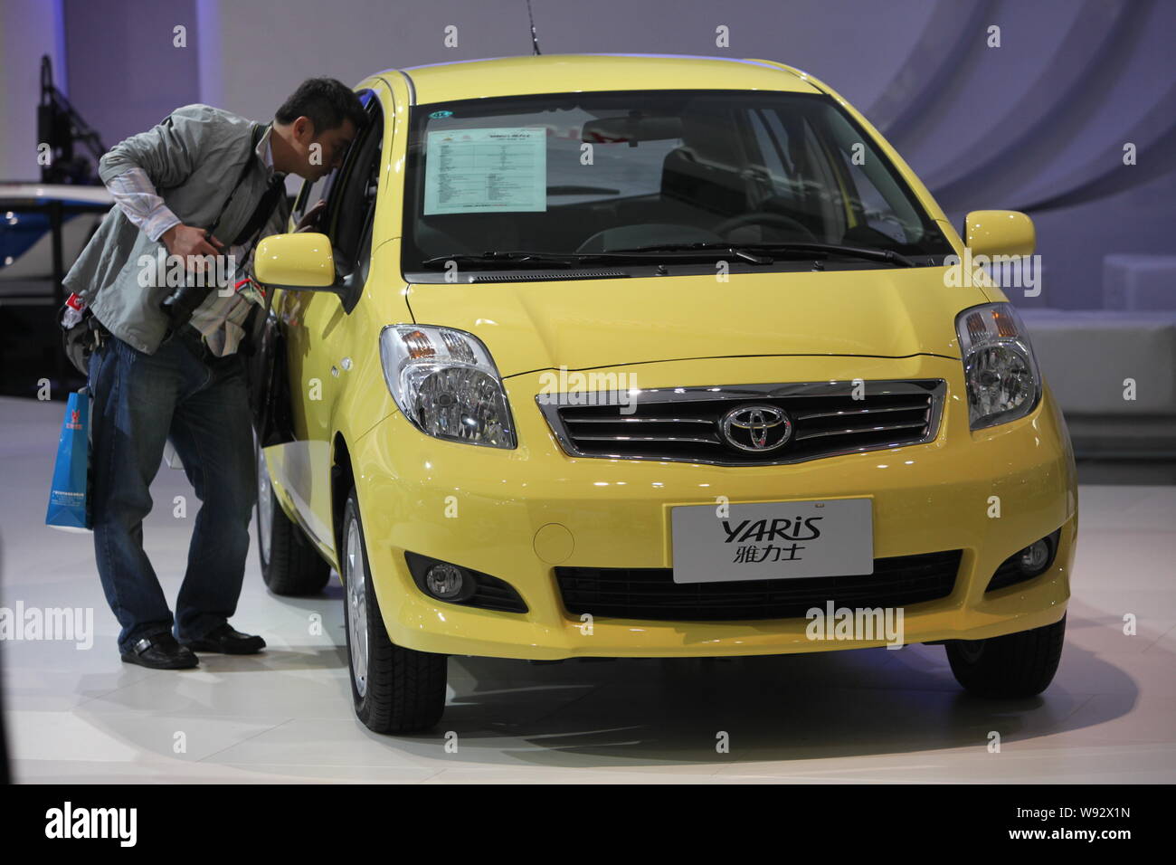 --FILE--A Chinese visitor looks at a Toyota Yaris during an automobile ...