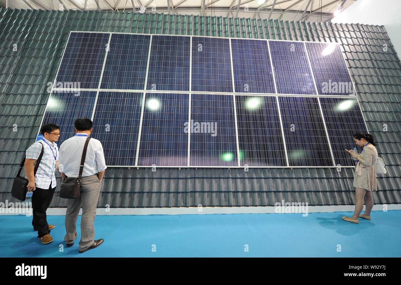 Chinese visitors look at models of solar panels during the 7th (2013 ...