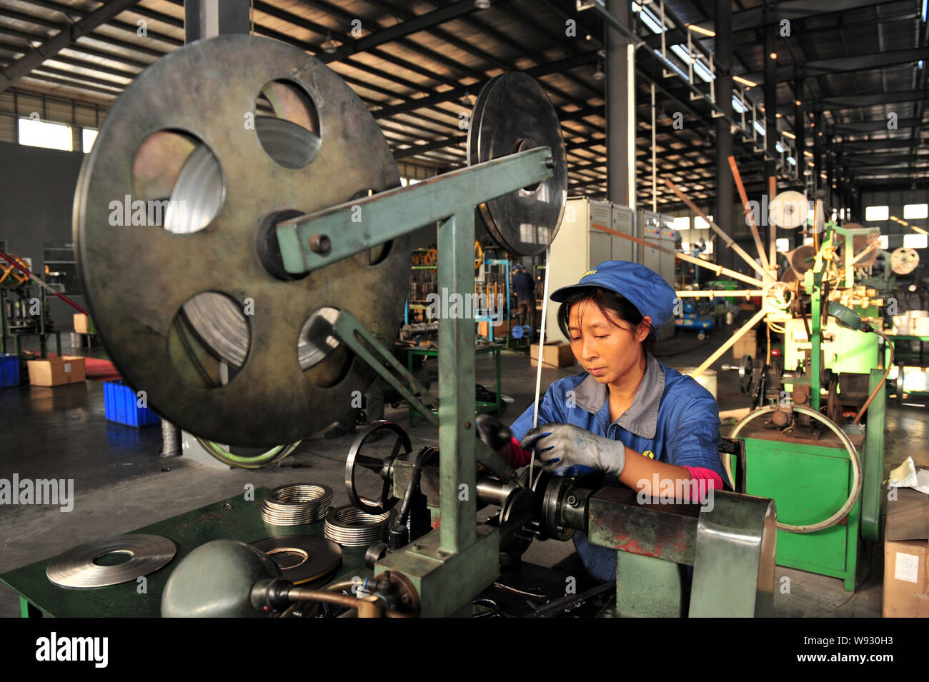 --FILE--A female Chinese worker processes graphite gaskets at a plant ...