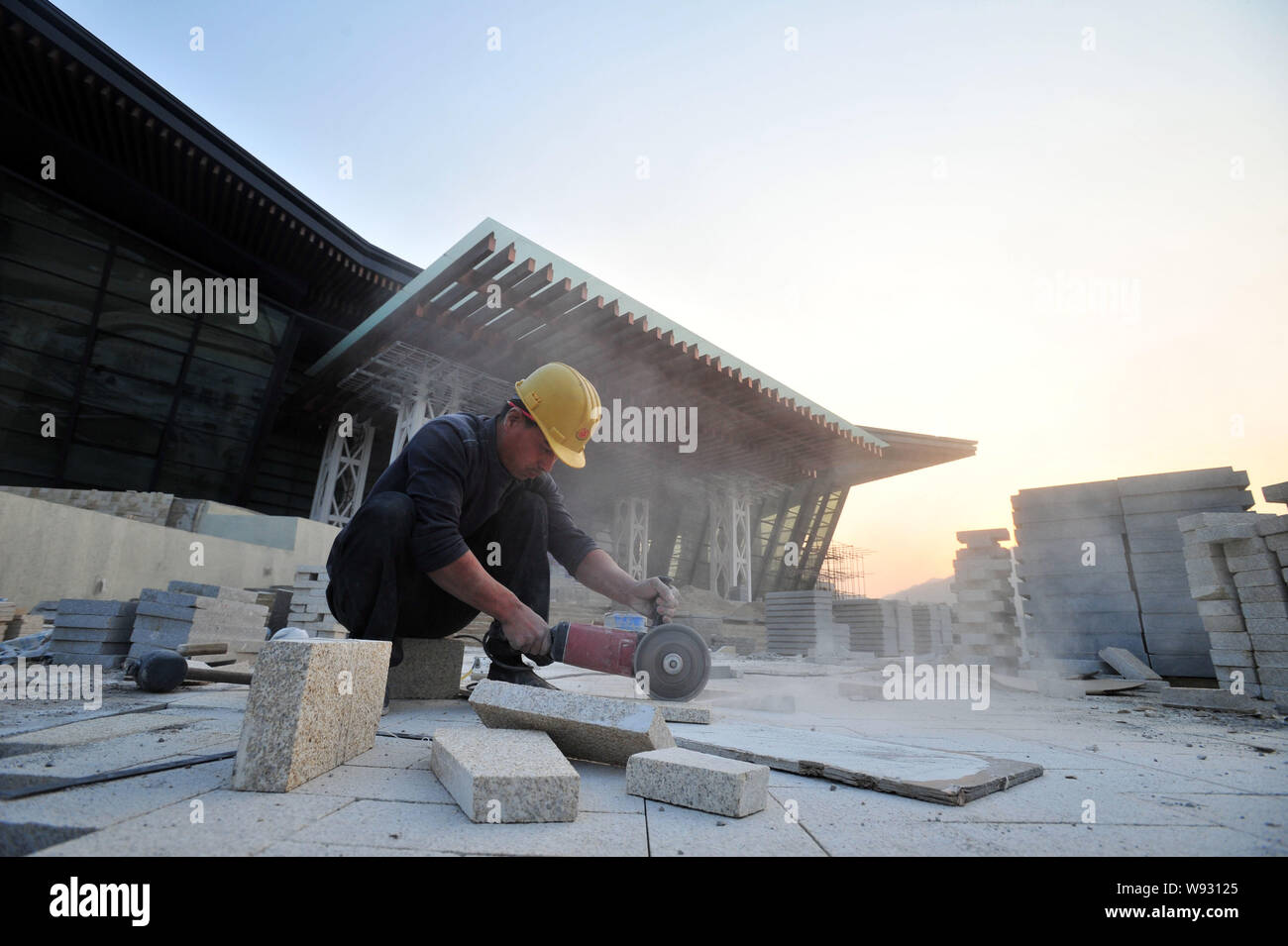 A Chinese worker labors in front of the conference center for the 2014 ...