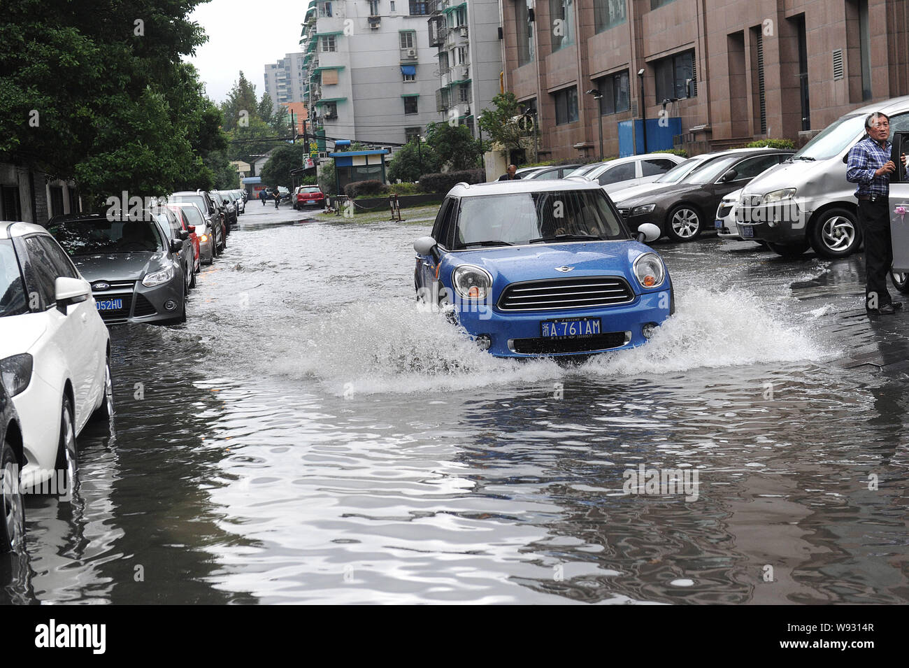 Half-submerged cars travel on a flooded street caused by typhoon Fitow ...