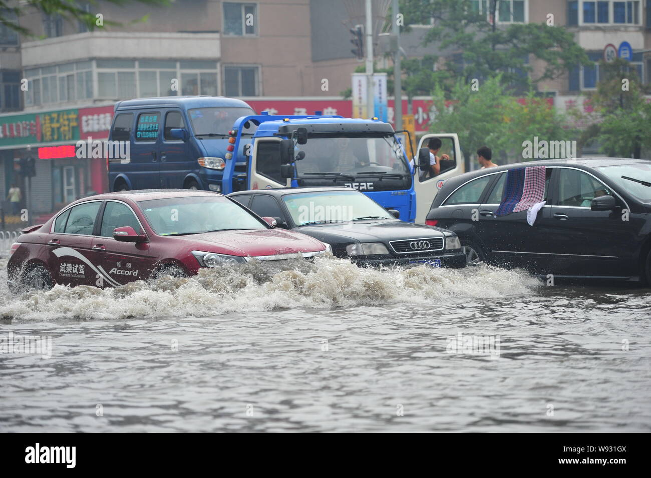 Cars travel on a flooded road caused by heavy rain in Shenyang city ...