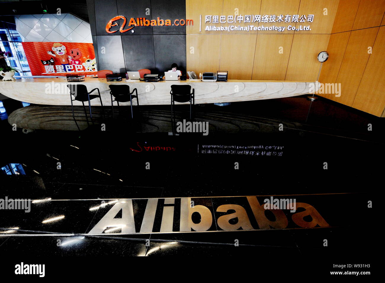 --FILE--A Chinese employee works at the reception desk in the ...