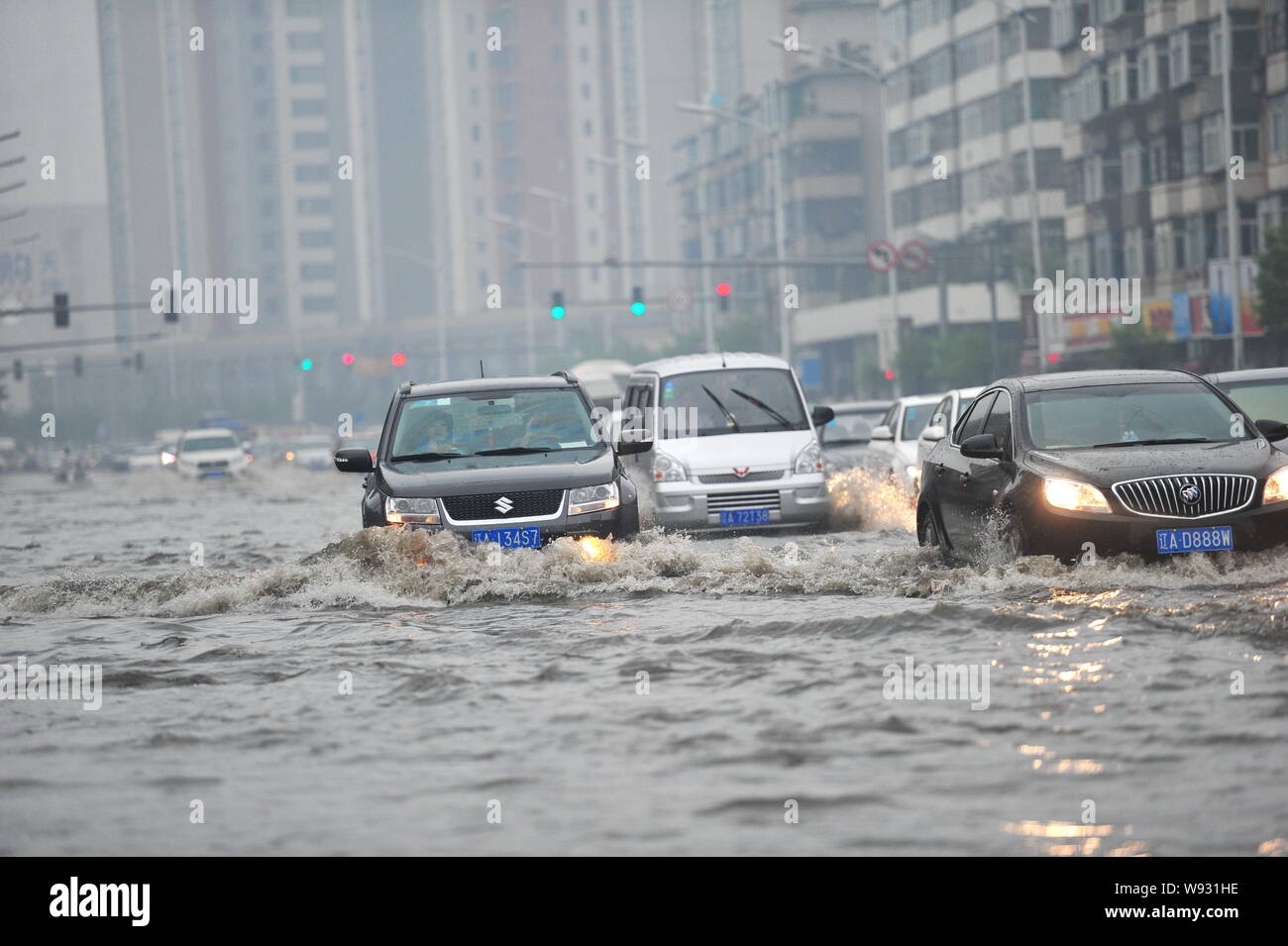 Cars travel on a flooded road caused by heavy rain in Shenyang city ...