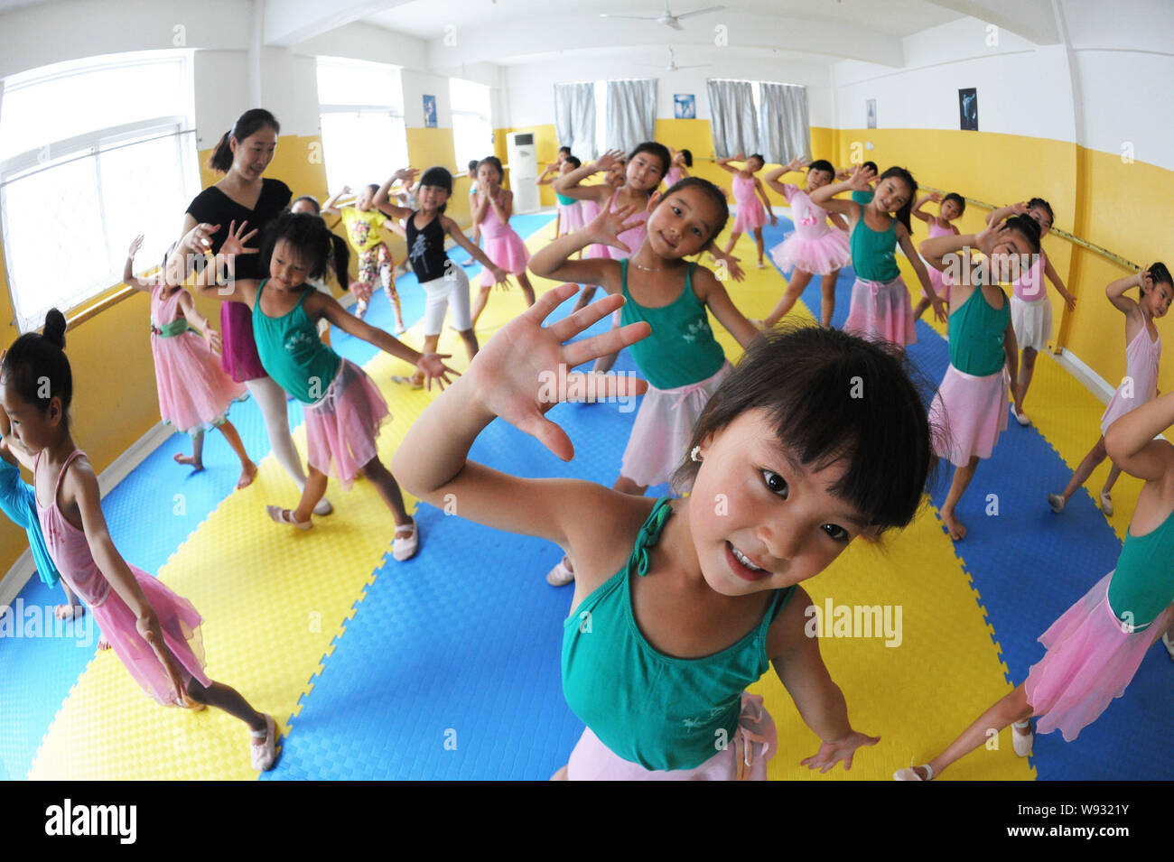 A teacher adjusts the posture of young Chinese girls to learn dancing ...