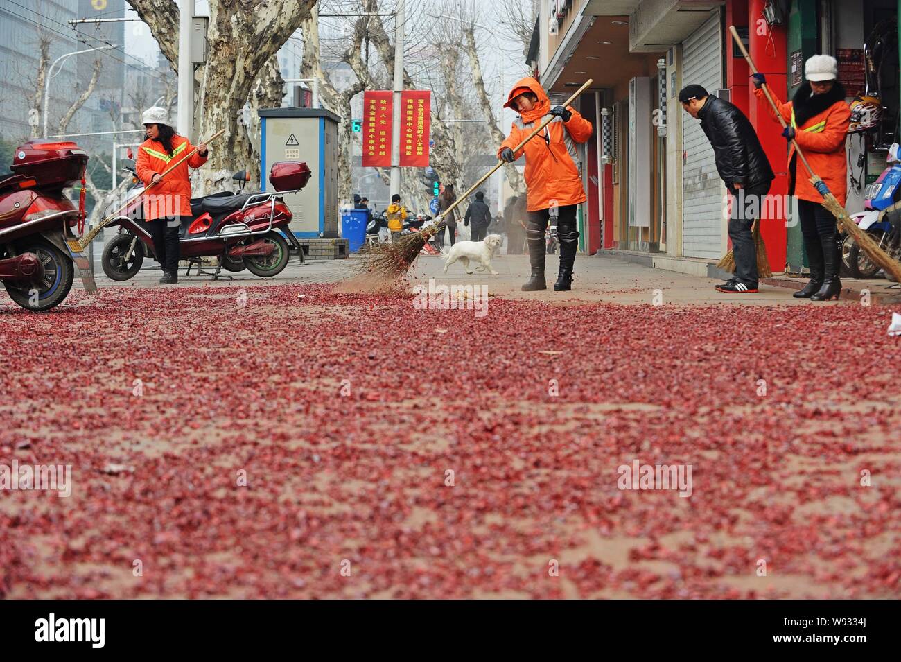 Chinese workers clear fireworks and firecracker rubbish on a street ...