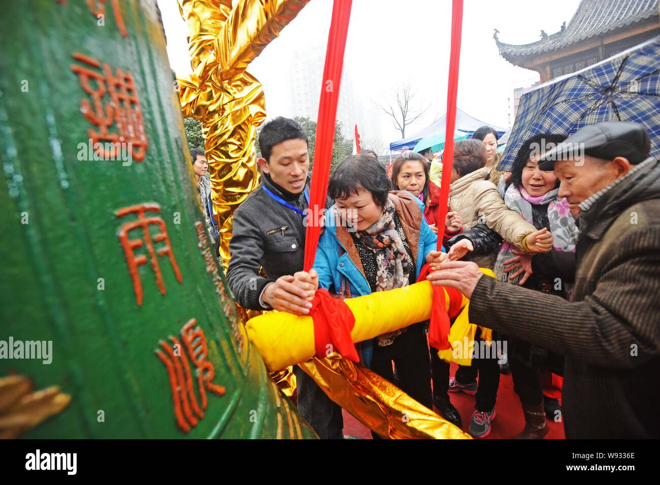 Chinese people strike a bell to pray for wealth at the Changchun Taoist ...