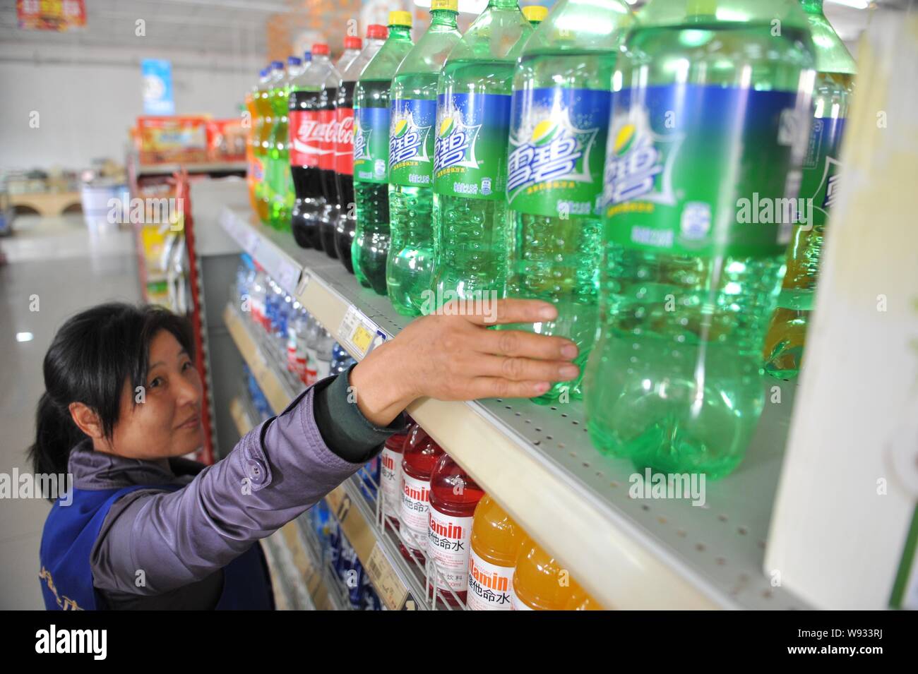 --FILE--A Chinese employee displays bottles of Sprite drink of Coca ...