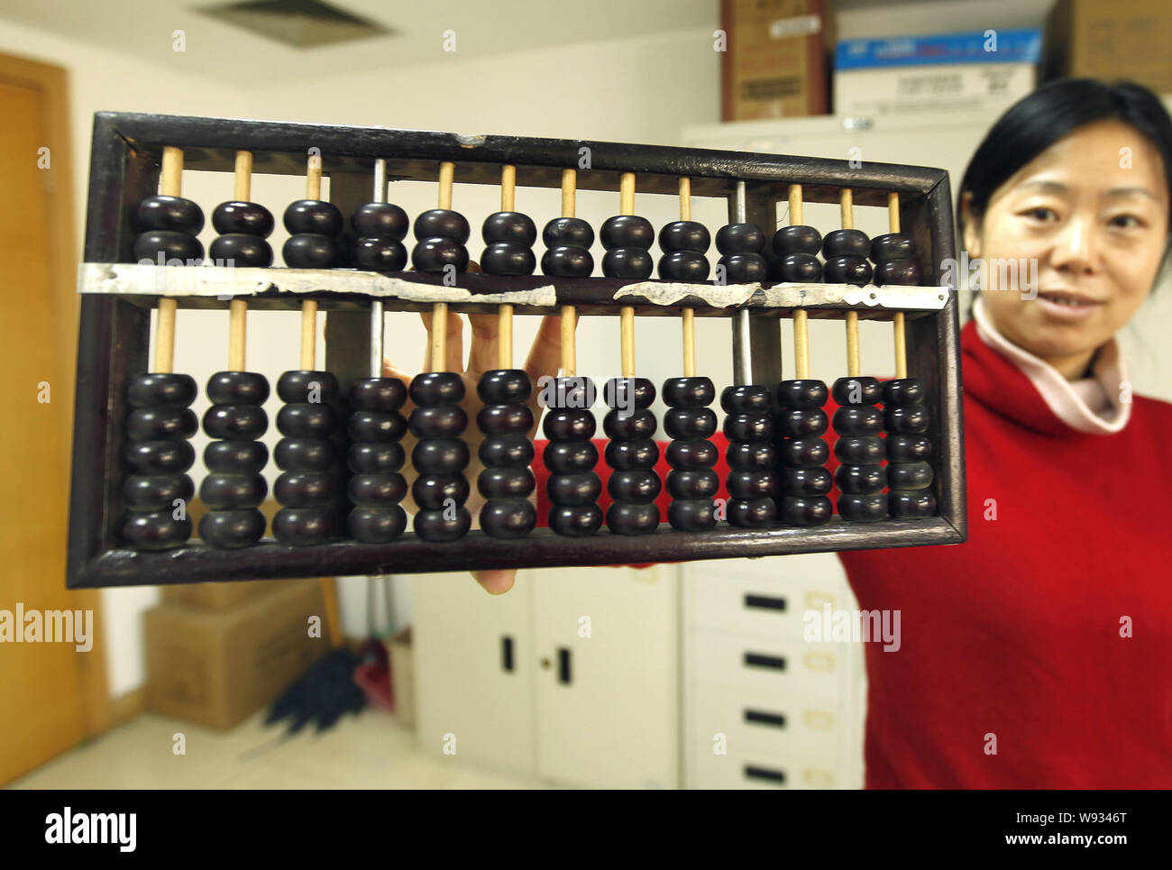 A Chinese accountant shows an abacus in XiAn city, northwest Chinas ...