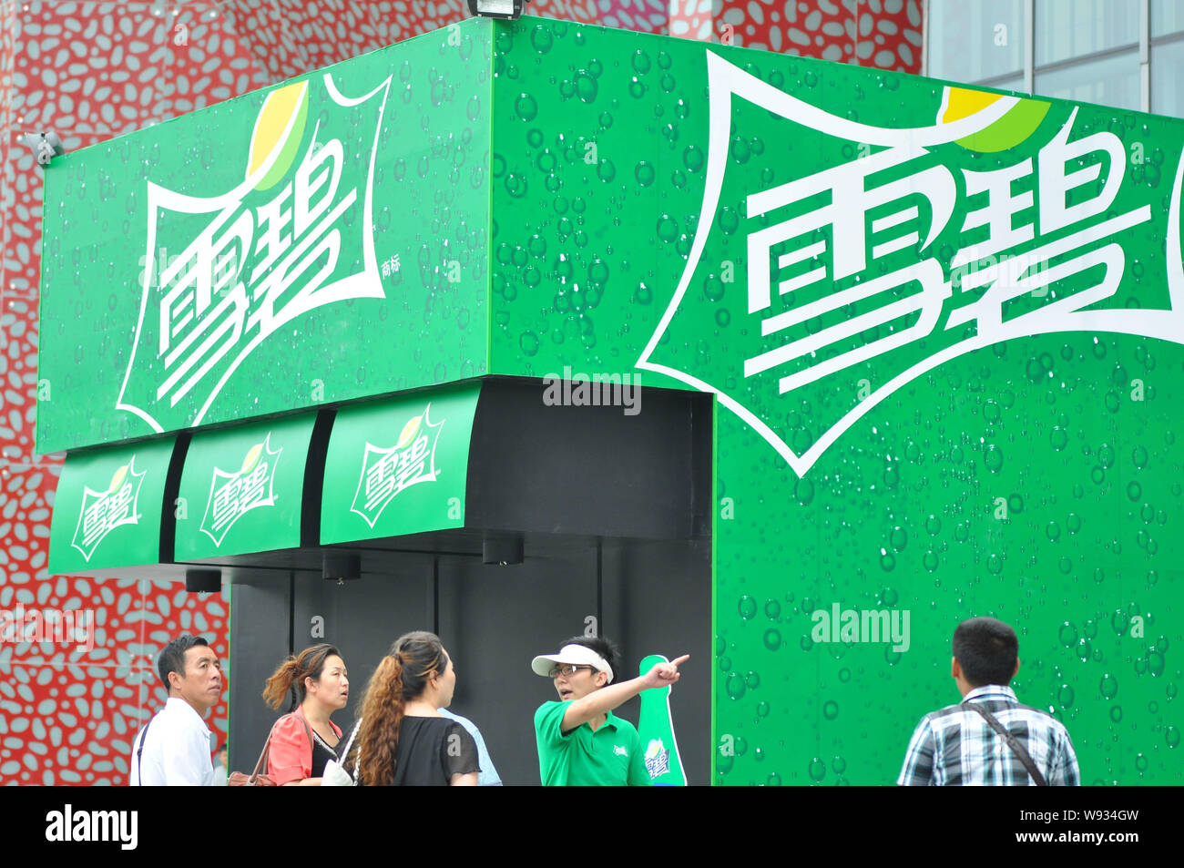 --FILE--Pedestrians walk past an advertisement for Sprite drinks of ... --FILE--Pedestrians walk past an advertisement for Sprite drinks of ...