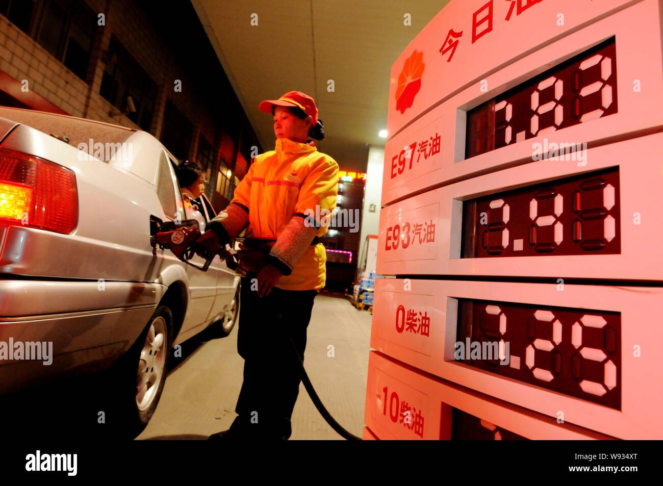 A Chinese worker refuels a car at a gas station in Luoyang city ...