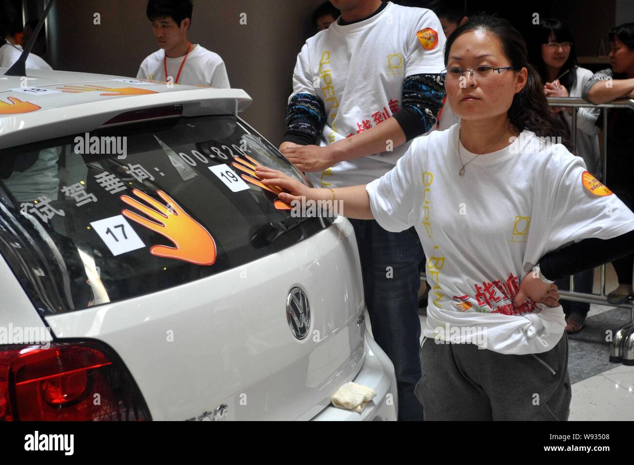 A Chinese contestant keeps one hand on a Volkswagen Polo GTI during a ...