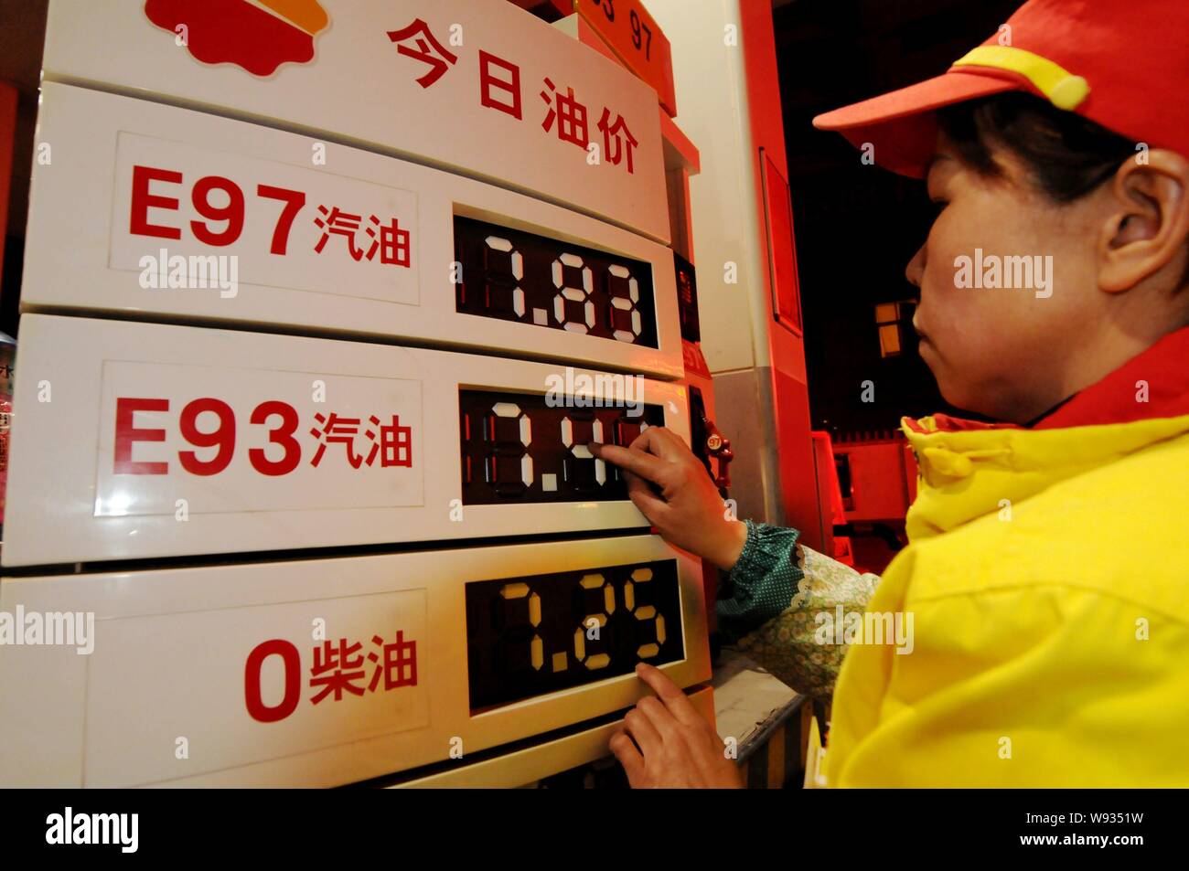 A Chinese worker updates fuel prices at a gas station in Luoyang city ...
