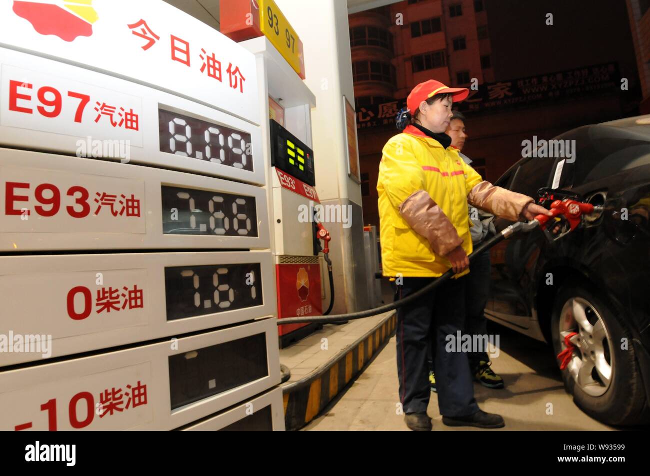 A Chinese worker refuels a car after midnight at a gas station of CNPC ...