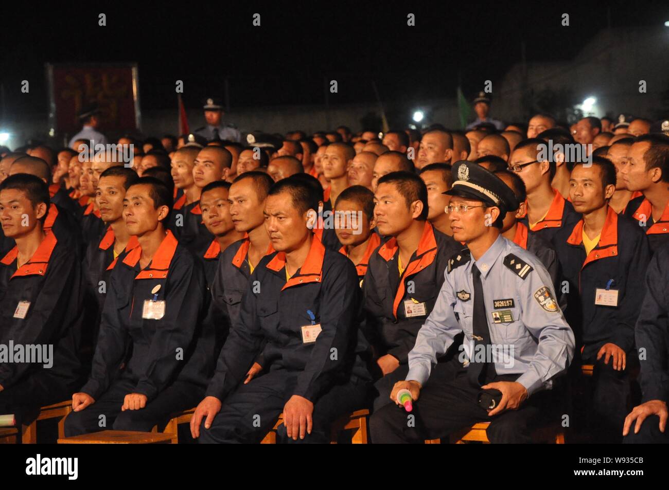 --FILE--A Chinese police officer sits with inmates during a gala to ...
