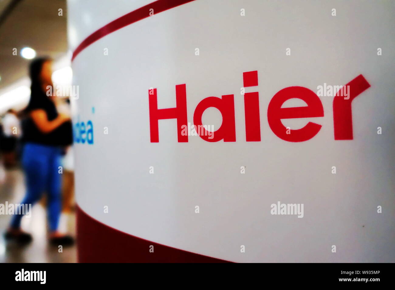--FILE--Pedestrians walk past the signage of Haier in Shanghai, China ...