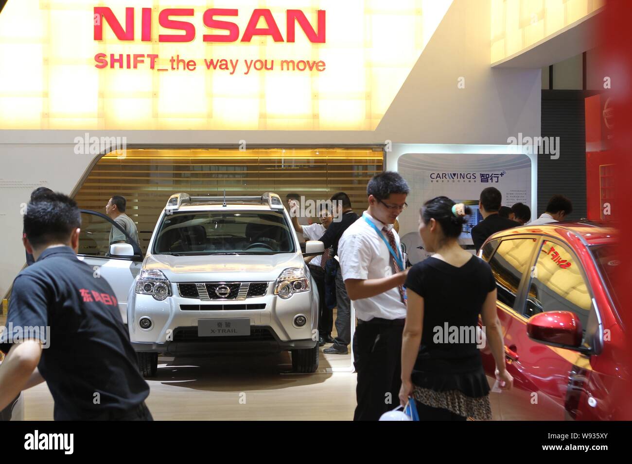 --FILE--Employees talk with visitors at the stand of Nissan during an ...