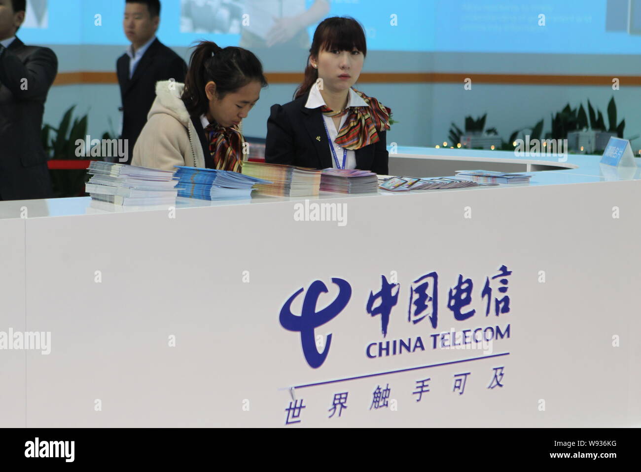 --FILE--Chinese employees are seen at the stand of China Telecom during ...