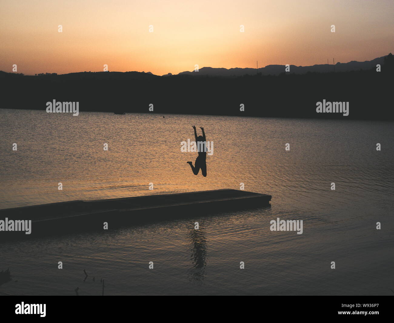 Jumping into lake girl silhouette hi-res stock photography and images ...