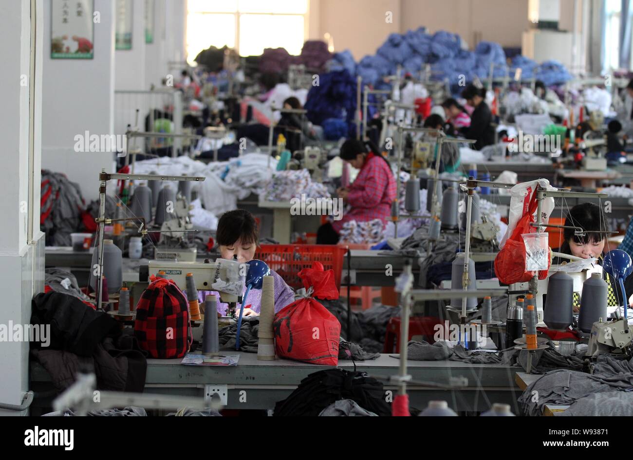 --FILE--Female Chinese workers sew clothes at a garment factory in ...