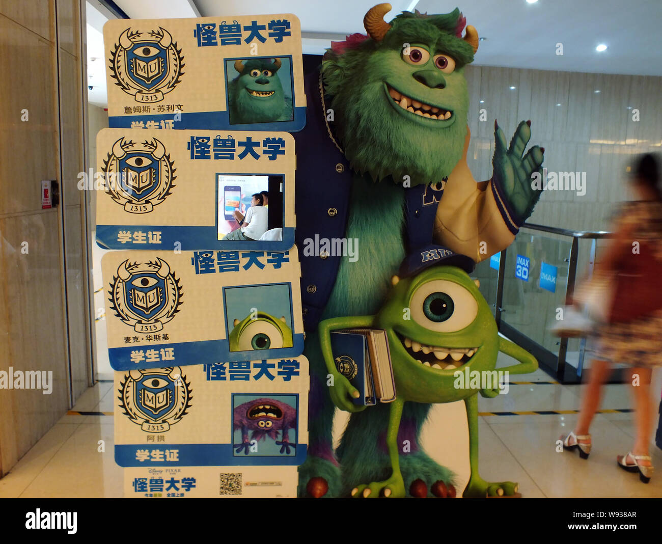 A Chinese moviegoer walks past a poster of the movie, Monsters ...