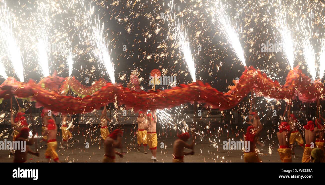 Dancers perform a fire dragon dance in a shower of molten iron during a ...