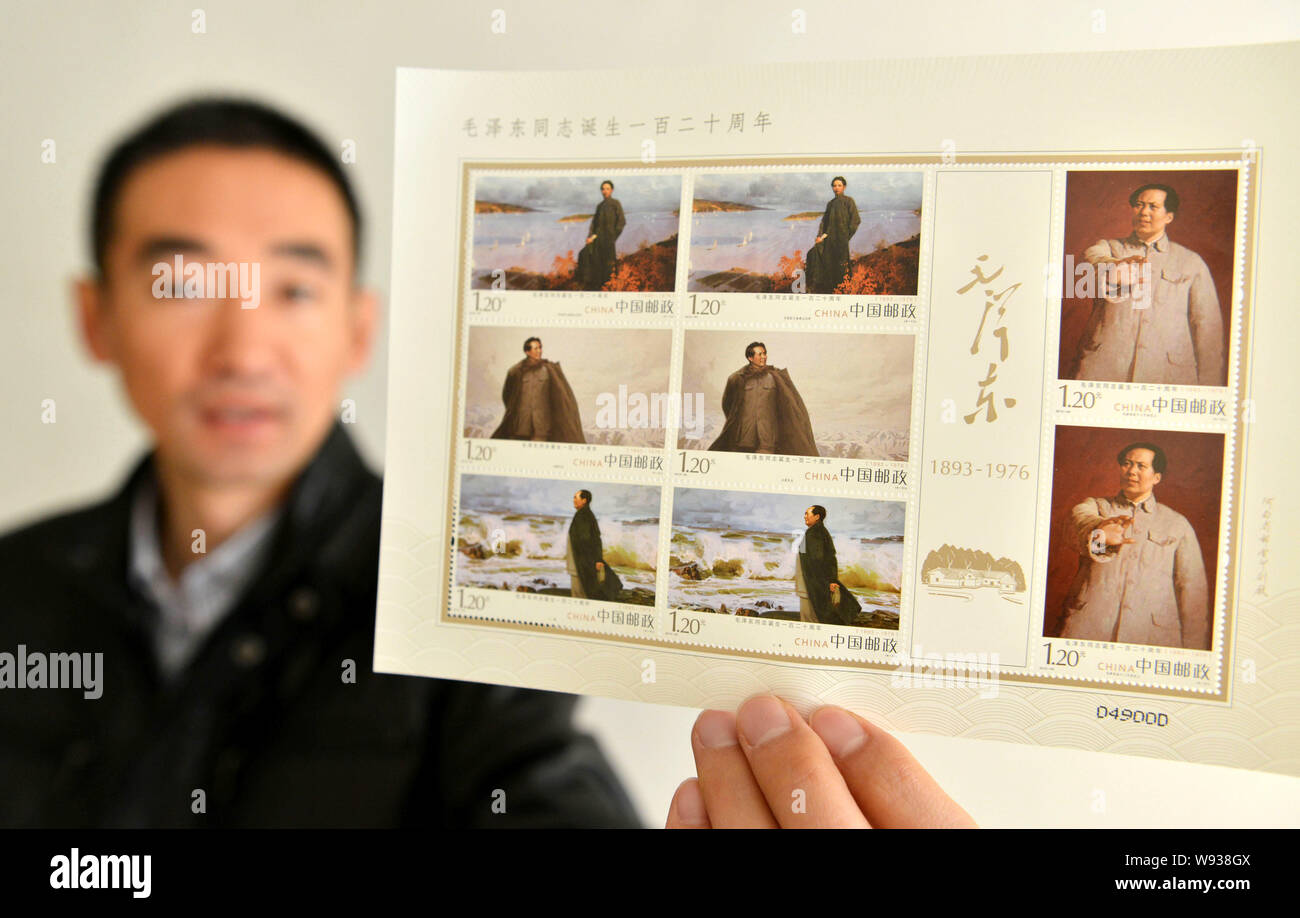 --FILE--A Chinese worker shows the stamps commemorating the 120th ...
