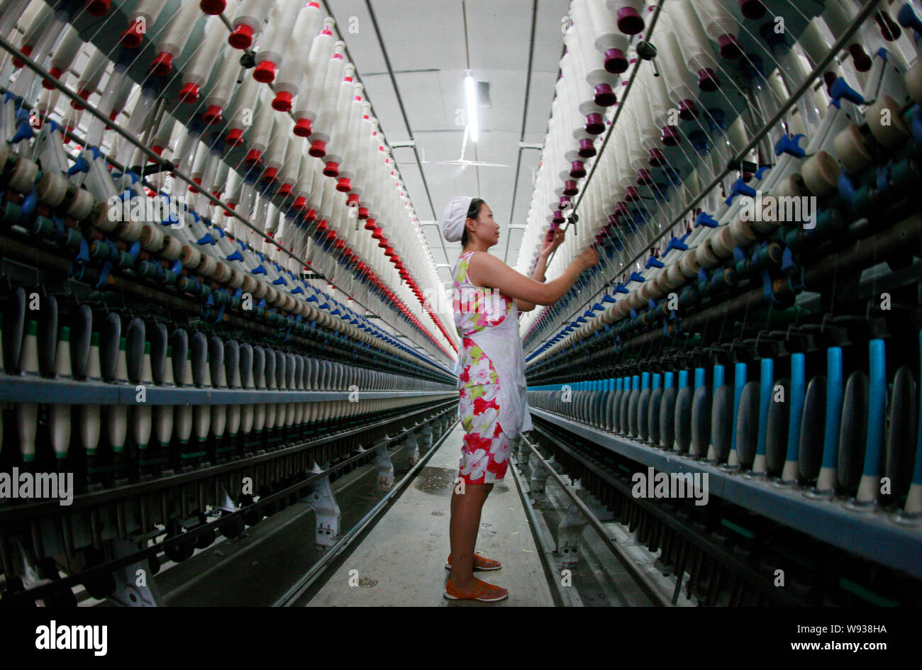 --FILE--A female Chinese worker handles production of yarn to be exported to Southeast Asia at a ...
