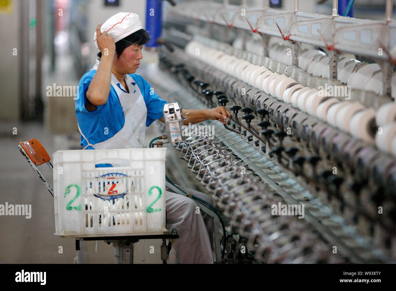 A female Chinese worker handles production of yarn to be exported to South Korea at a textile ...