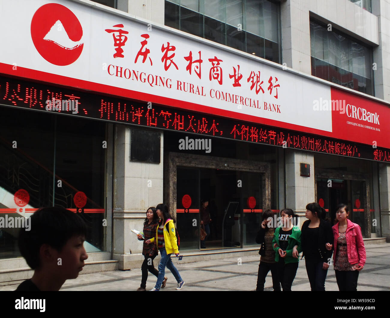--FILE--Pedestrians walk past a branch of Chongqing Rural Commercial ...