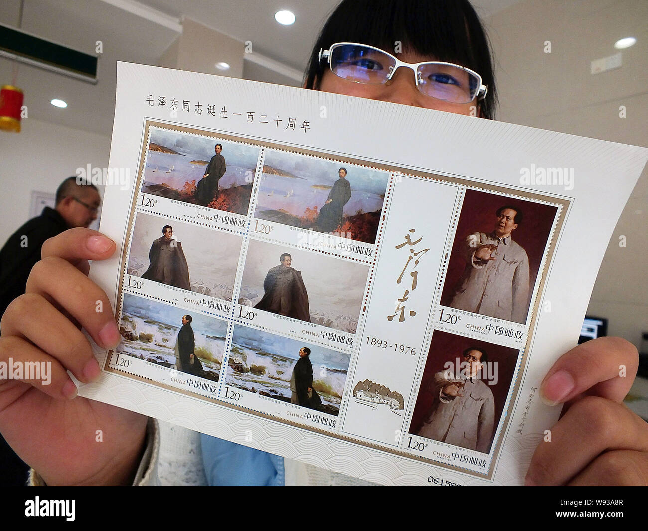 --FILE--A Chinese resident shows the stamps commemorating the 120th ...