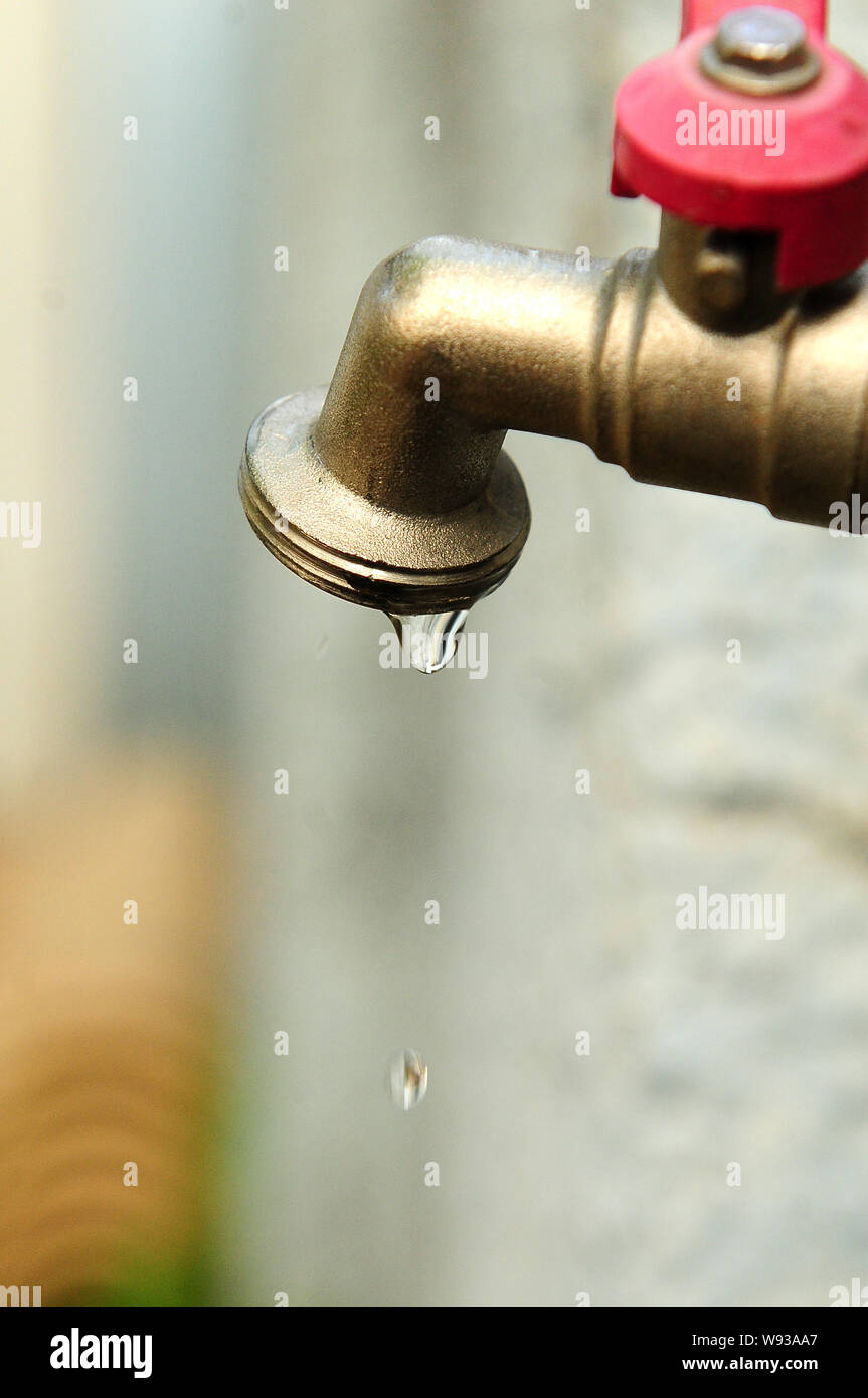 faucet dripping water with blurred background Stock Photo - Alamy