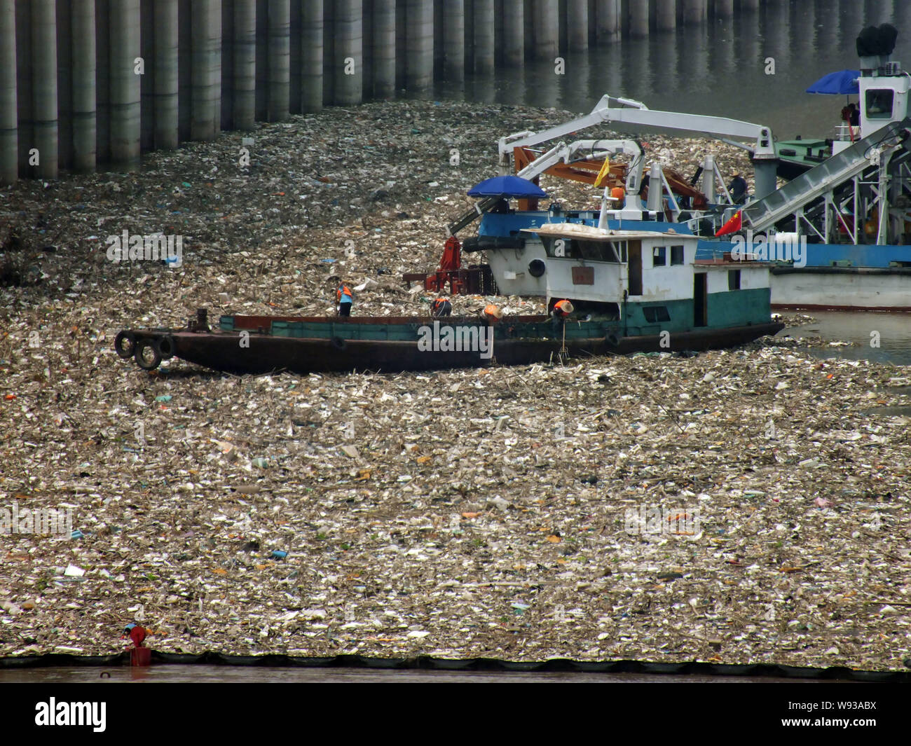 Chinese workers and cleaning boats collect garbage floating on the ...