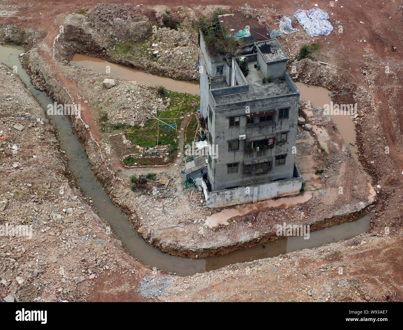 A nail house is isolated by man-made ditches on the jobsite of a ...