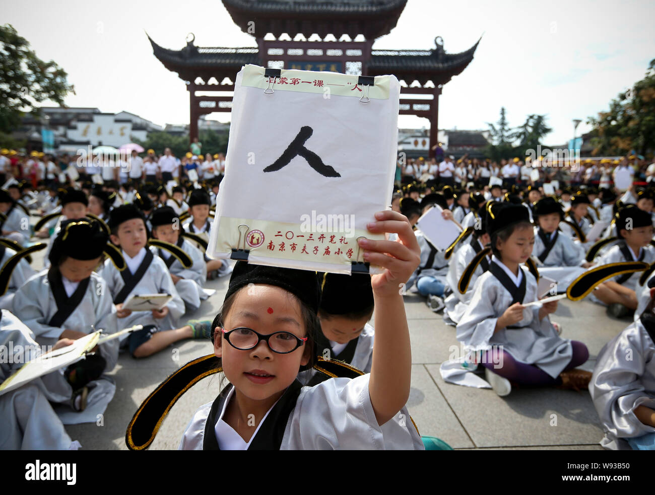 A first-grade pupil holds up her calligraphic writing of the Chinese ...