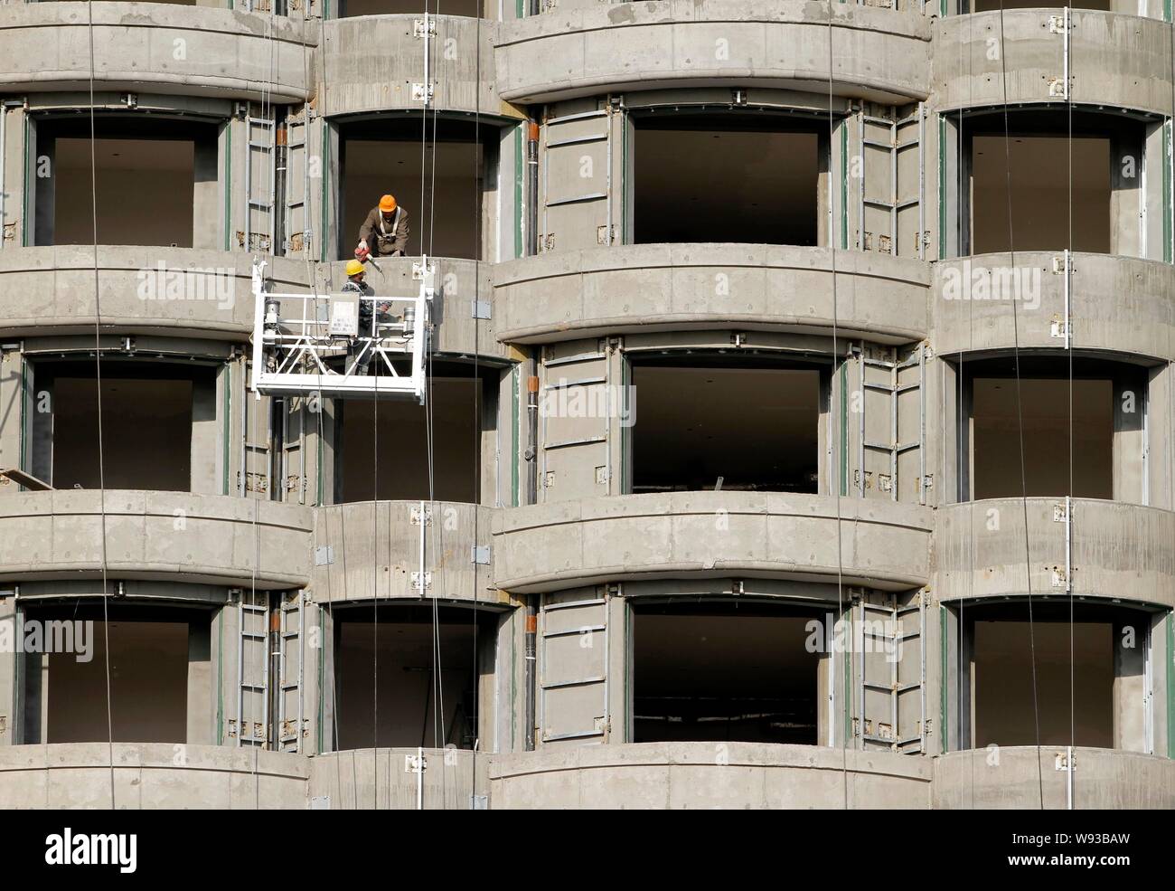 --FILE--Chinese migrant workers labor on a new high-rise residential ...