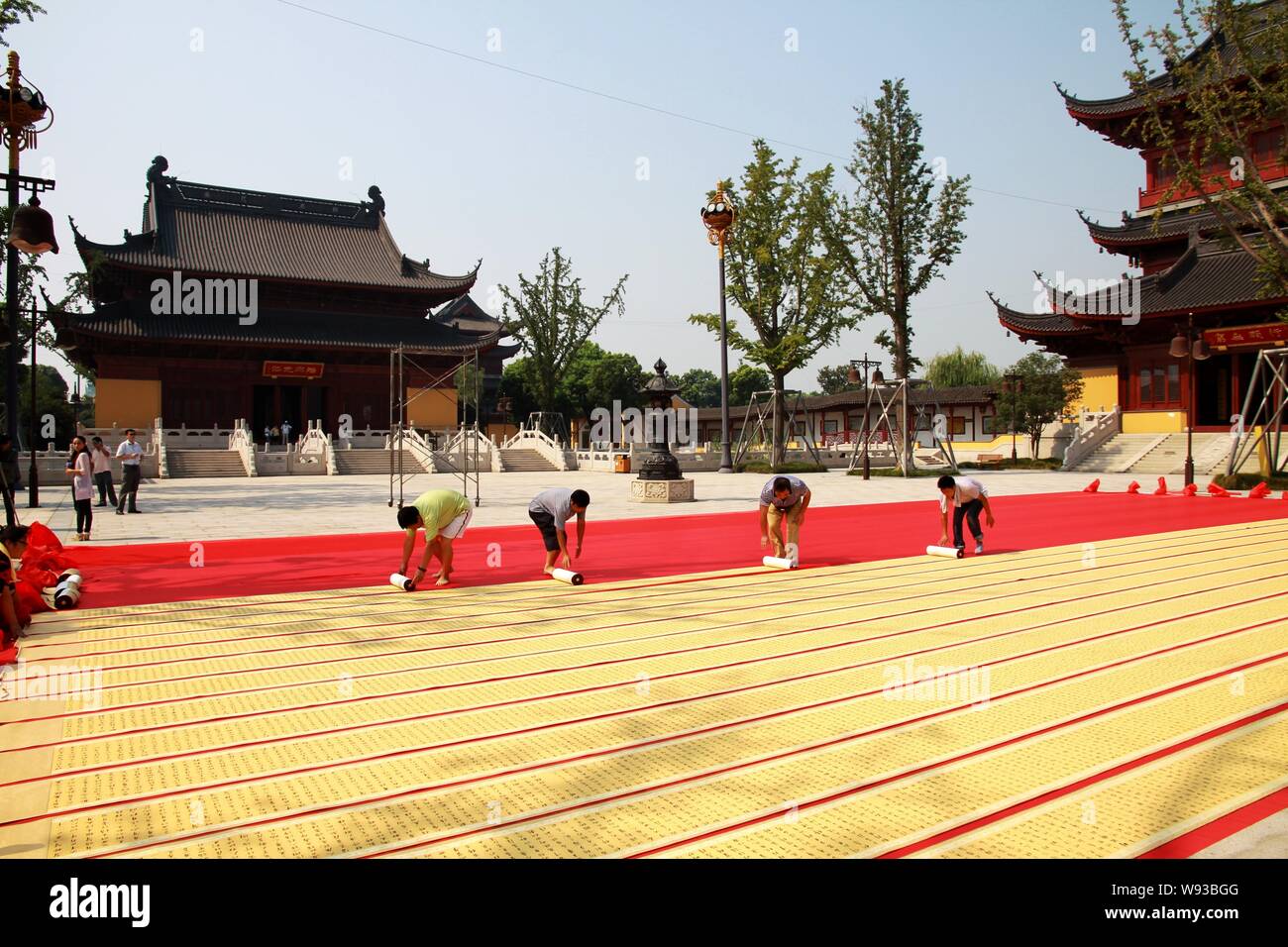 Employees of the World Record Association unfold scrolls of calligraphy ...