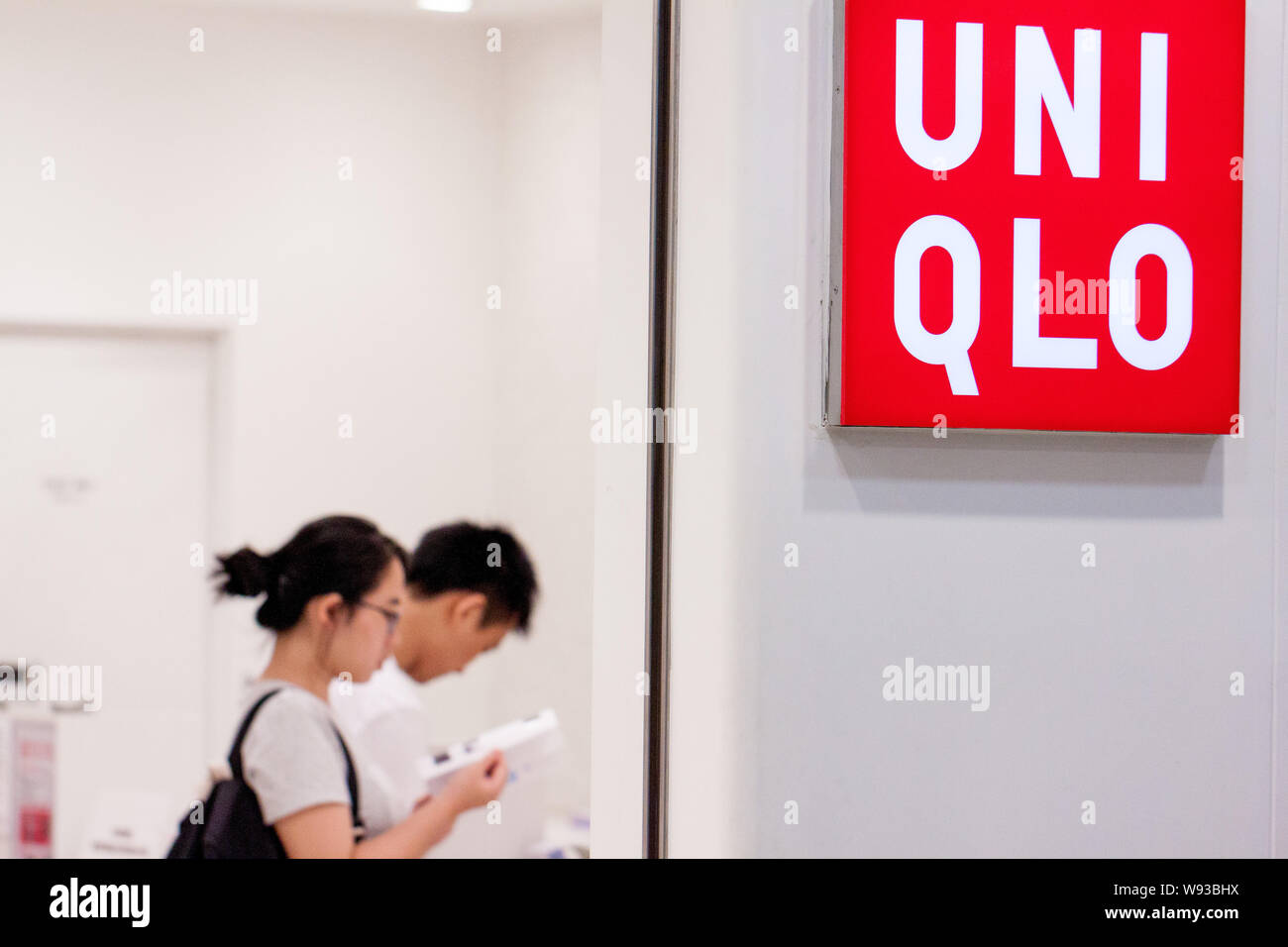 --FILE--A customer reads a brochure at the cash desk of a Uniqlo store ...
