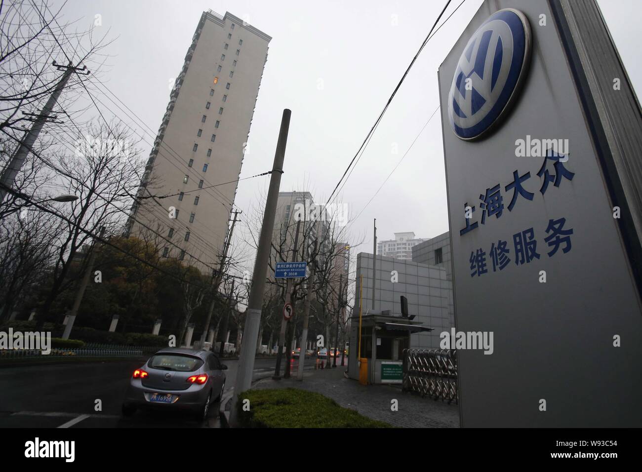 A car passes by a dealership of Shanghai Volkswagen, a joint venture ...