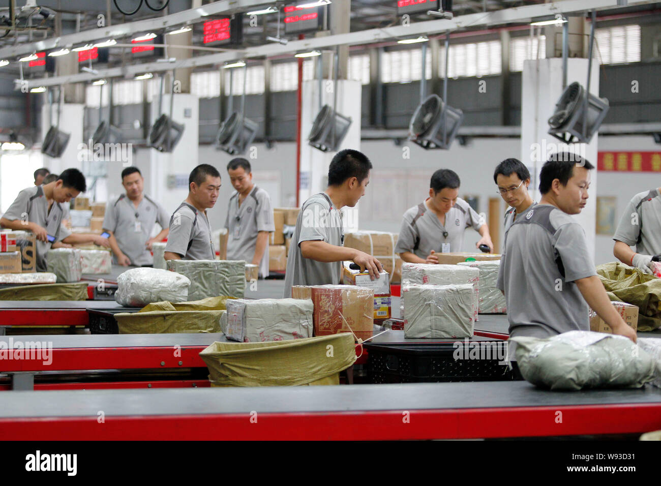 Chinese workers sort parcels, most of which come from online shopping ...